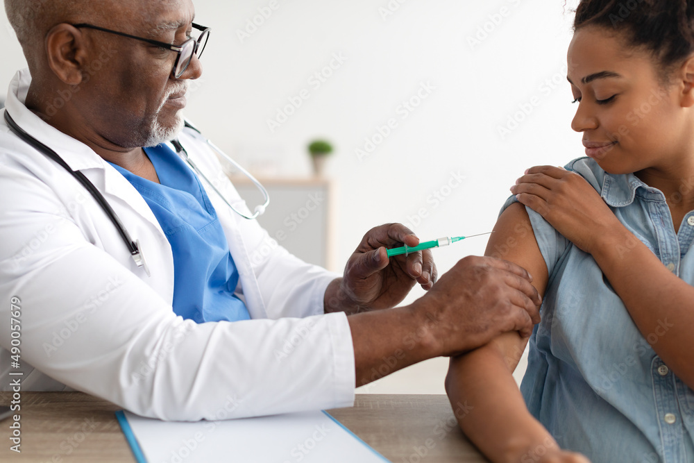 Black Woman Receiving Vaccine Injection Sitting With Doctor Indoor ...