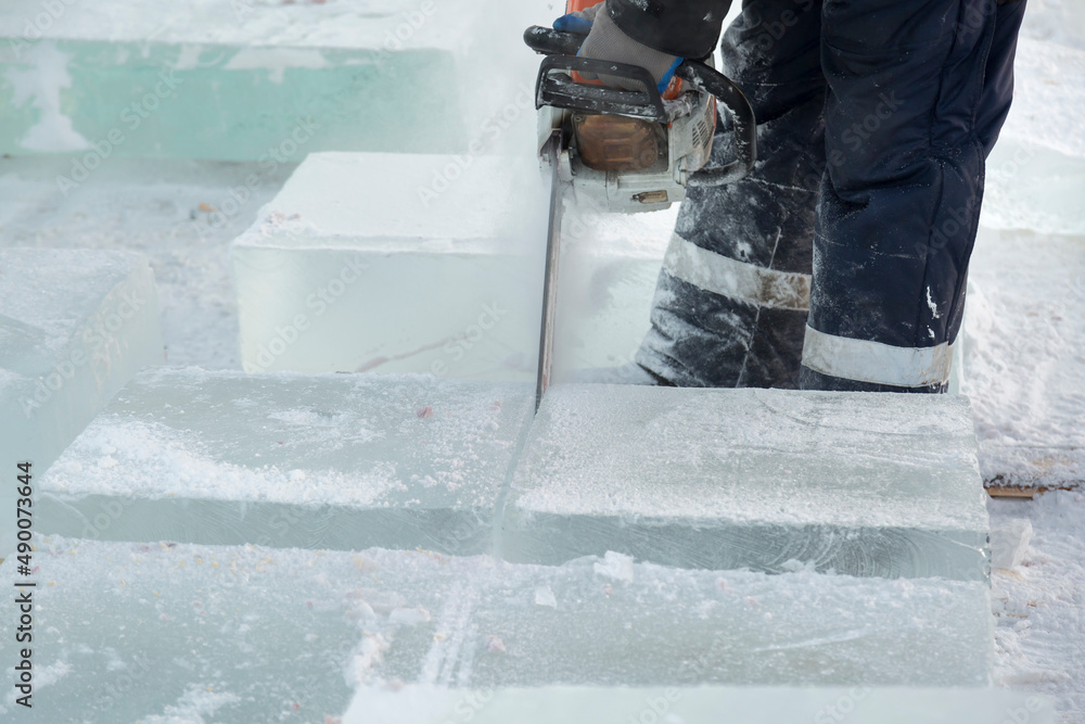 Worker cuts a lump of ice with a chainsaw Stock Photo | Adobe Stock