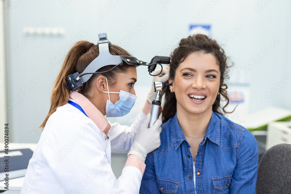 Foto de Hearing exam. Otolaryngologist doctor checking woman's ear ...