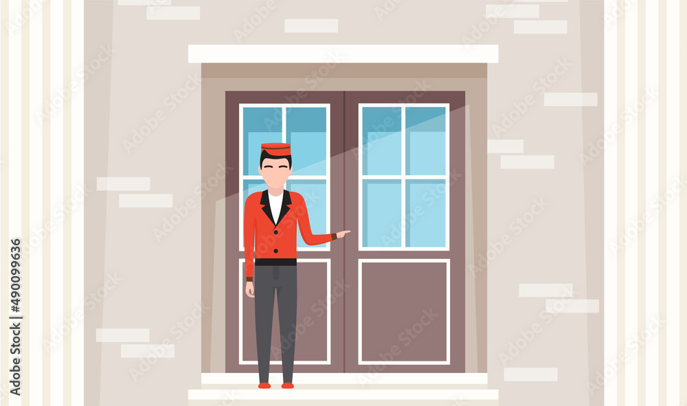 Doorman standing in front of hotel entrance doors. Young man in uniform ...