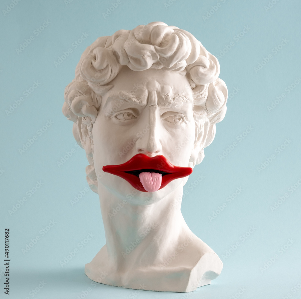 Statue of David head with with red lips and protruding tongue on blue ...