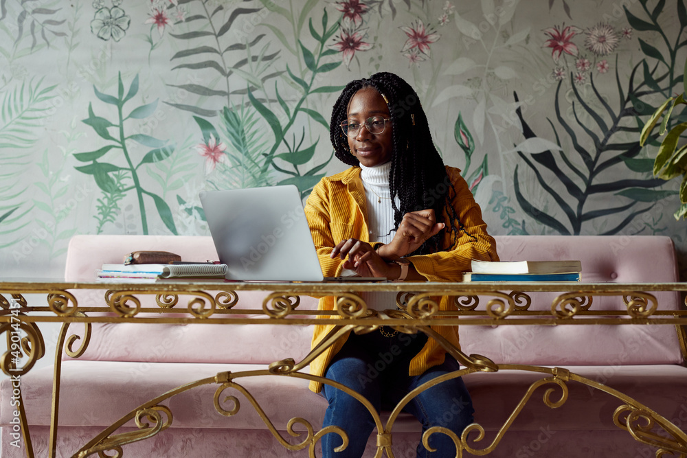 An African female student on student exchange is sitting in a cafe and ...