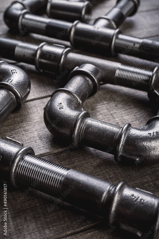 Cast iron pipes and fittings of different shape and forms, laying on a ...