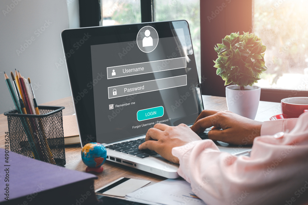 Person hand typing on keyboard with login and password on screen ...
