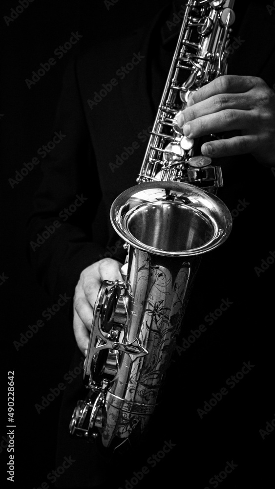 Grayscale of a man's hand playing a saxophone Stock Photo | Adobe Stock