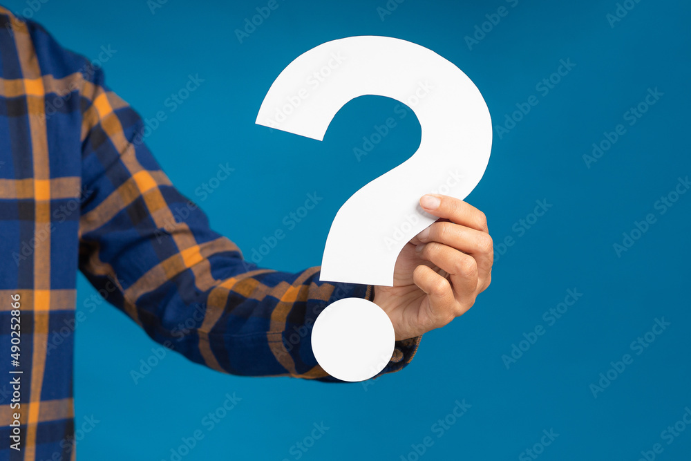 Hand holding a white question mark against a blue background Stock ...