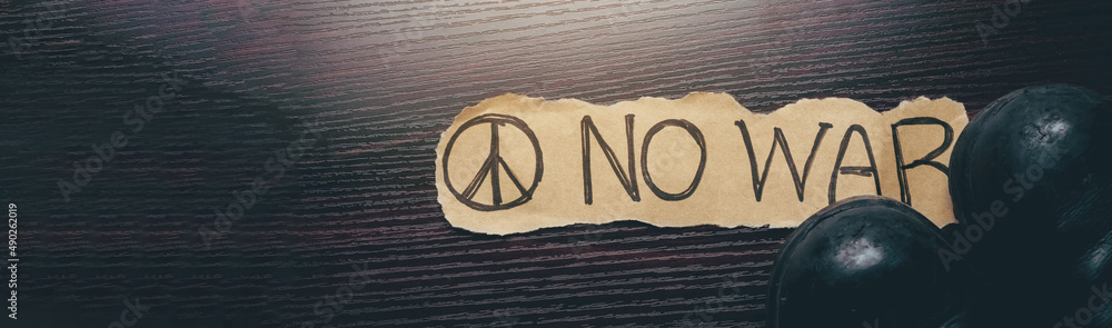 Soldier' Combat Boot stomp pieces of paper with words NO WAR message ...