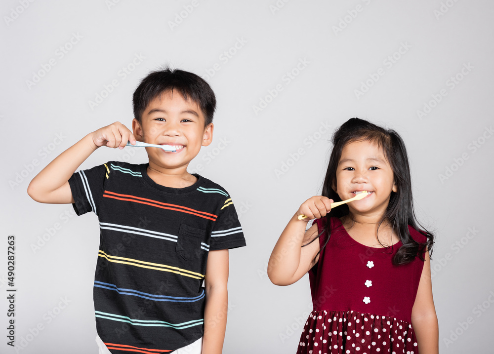 Little cute kid boy and girl 3-6 years old brushing teeth and smile in ...