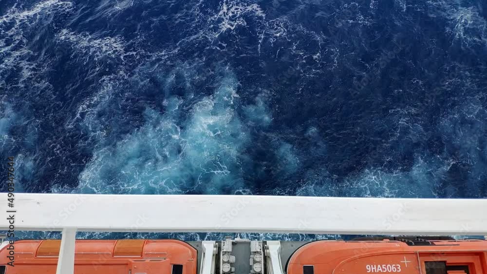 Sea water to the sides of a cruiser while navigating. Orange life boats ...