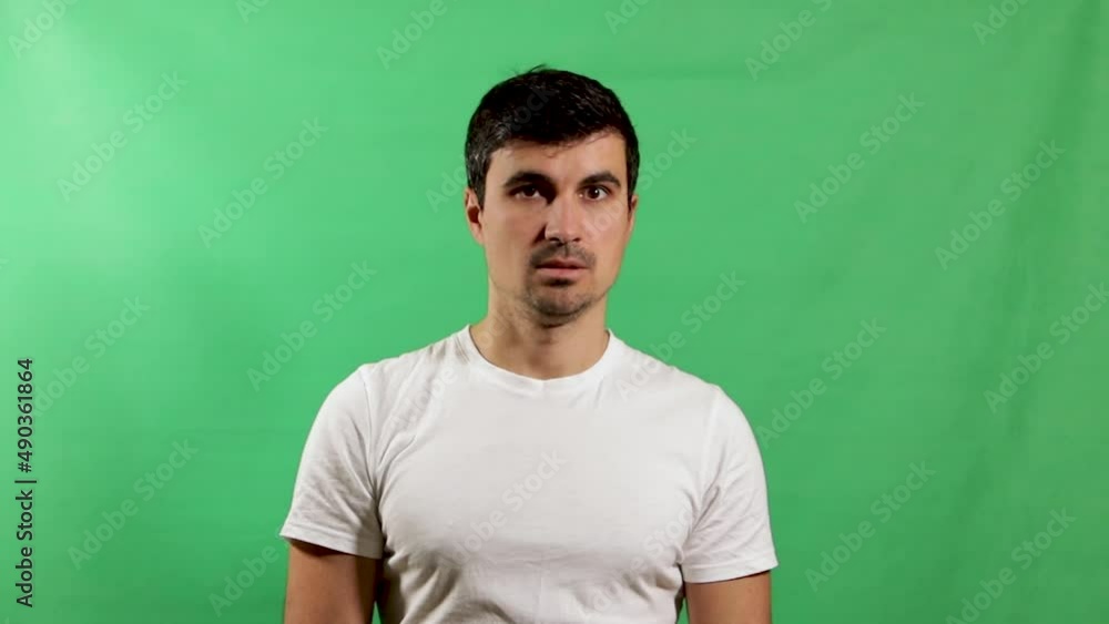 Vidéo Stock A handsome young man in a white shirt looks around and ...