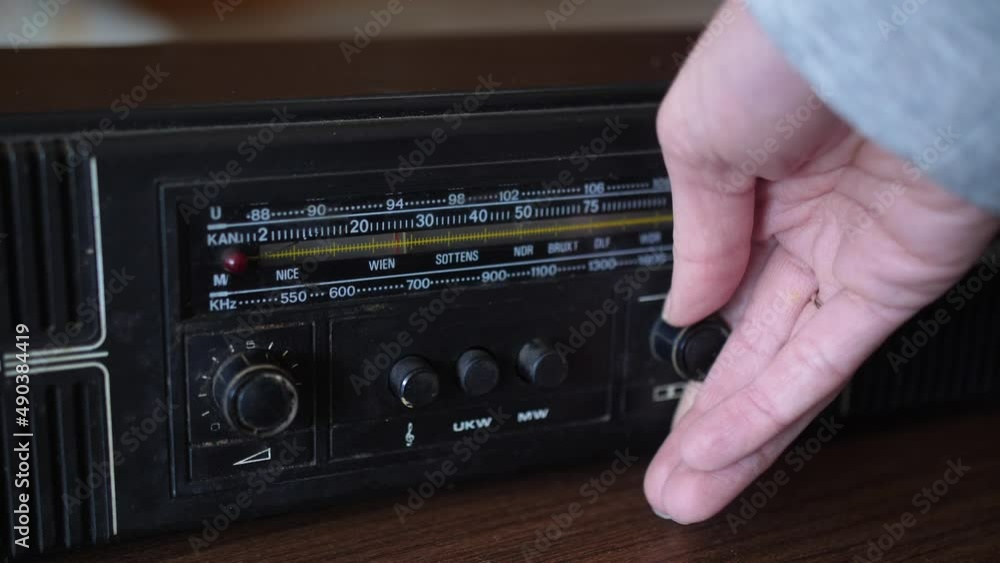 female tuning frequency on retro radio with city name scale, dark ...