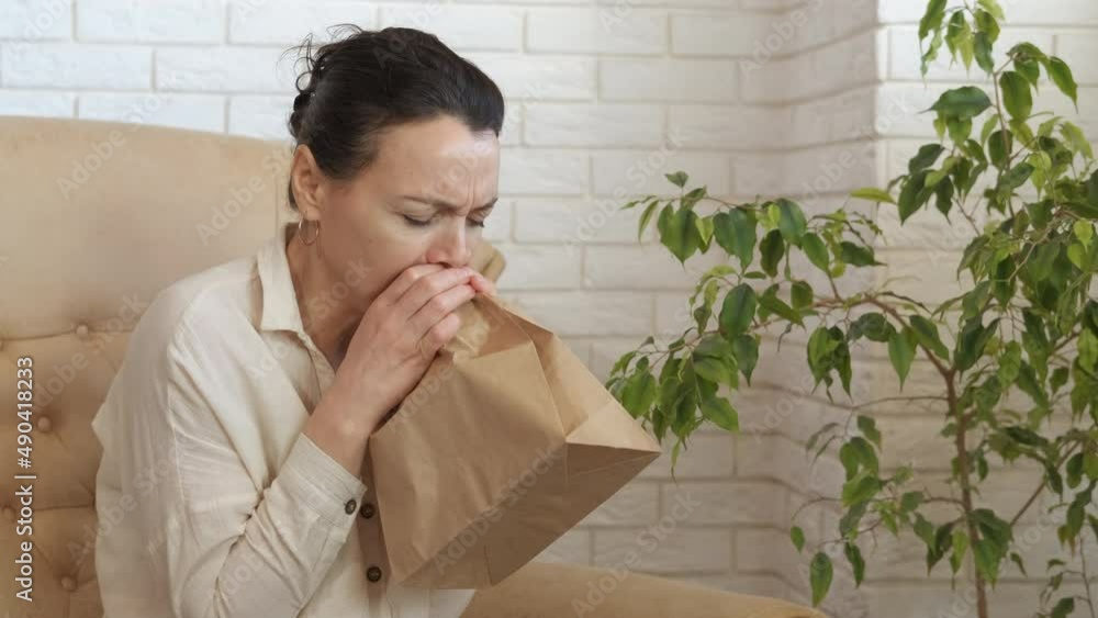 Sick woman breathe into the bag. An upset woman make no stress while ...