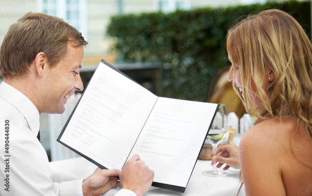 He know what he wants.... A rear view of a couple looking at a menu ...