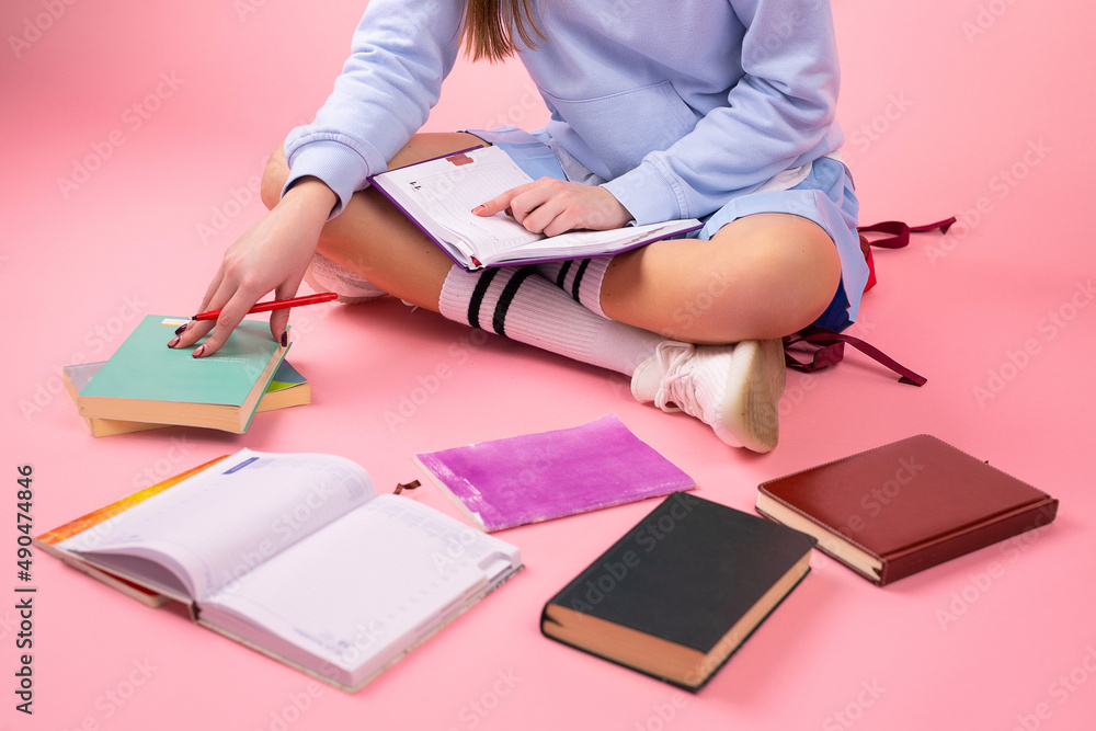 Cropped photo of a young school girl sitting on the floor with crossed ...