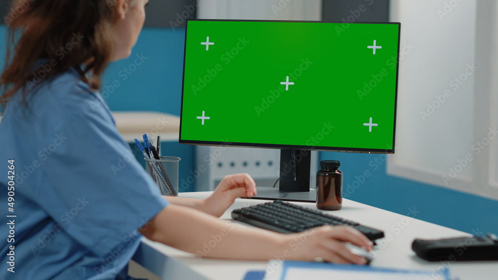 Close up of woman nurse looking at horizontal green screen on computer ...
