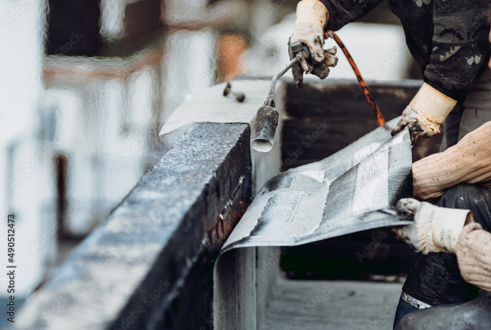Professional workers waterproofing house construction site. Worker ...