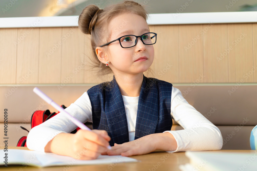 surprised schoolgirl in glasses looking at the teacher. studying ...