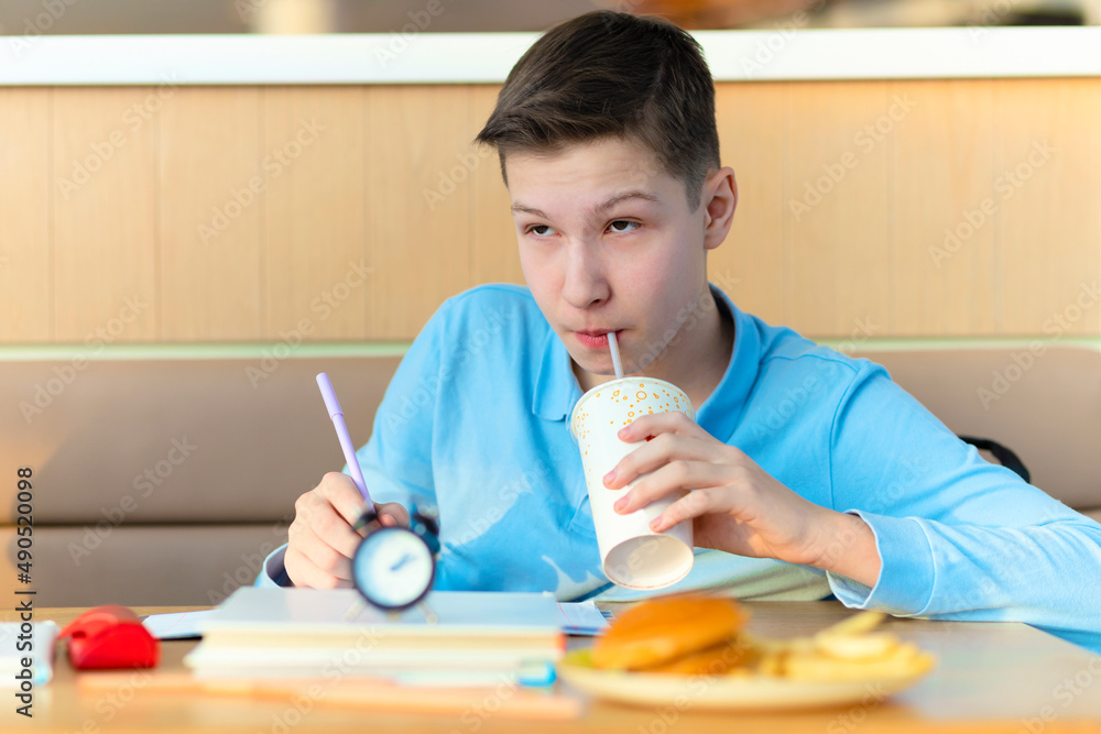 schoolchild doing homework, studing at school. boy waiting for lunch ...