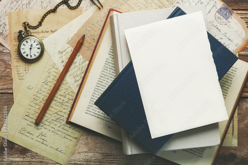 White writing sheet with copy space on top of books and postcards Stock ...