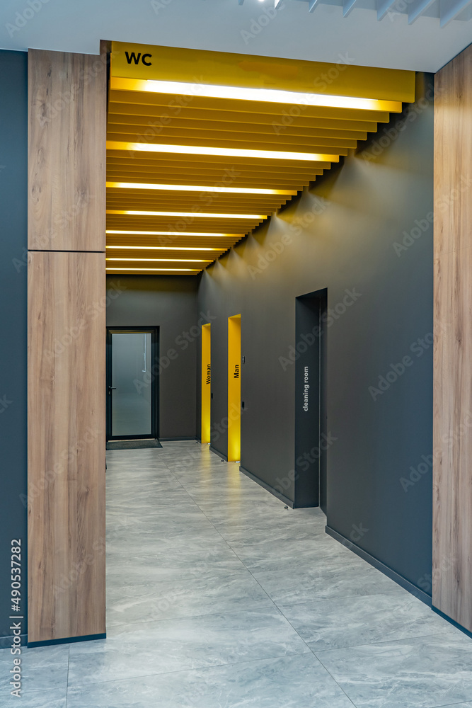 Perspective of a long corridor in office building. Doors of washrooms ...
