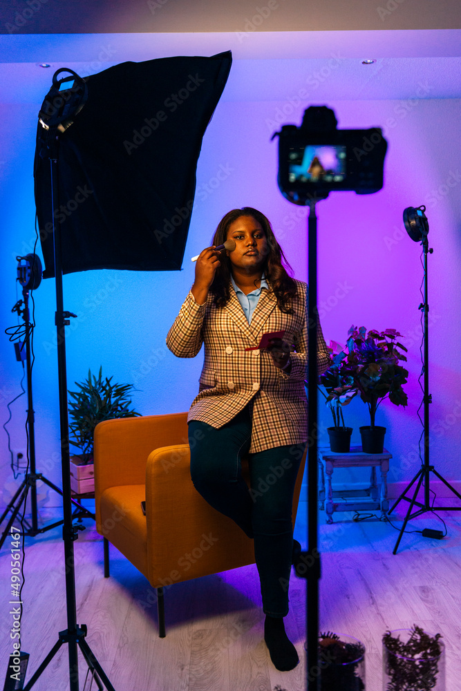 Plus size young black woman vlogging on chair at home studio Stock Photo | Adobe Stock