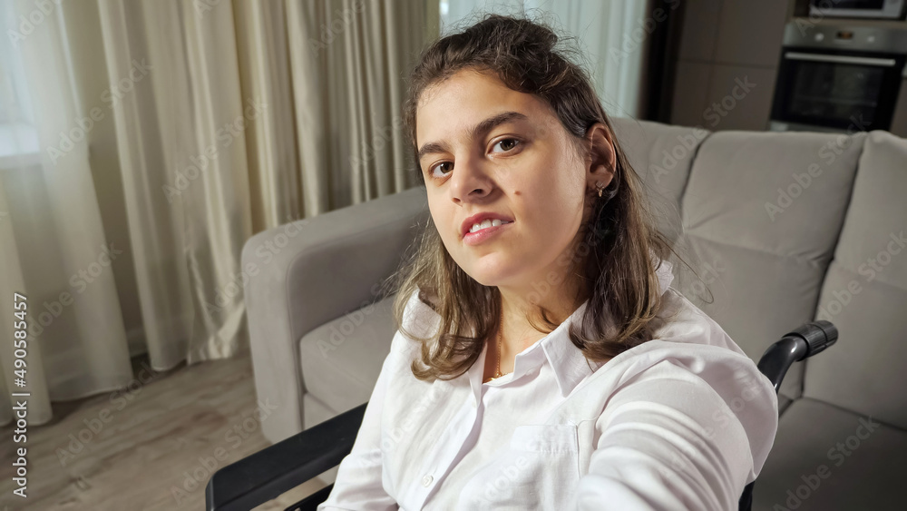 Foto de Disabled woman with cerebral palsy smiles sitting in wheelchair ...