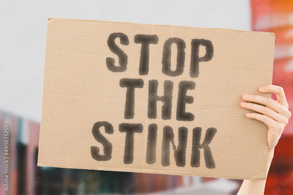 The phrase " Stop the stink " on a banner in men's hand with blurred ...