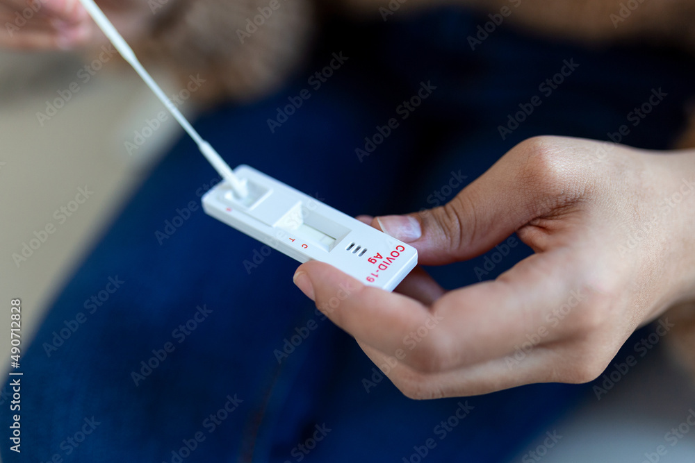 African-American woman using cotton swab while doing coronavirus PCR ...