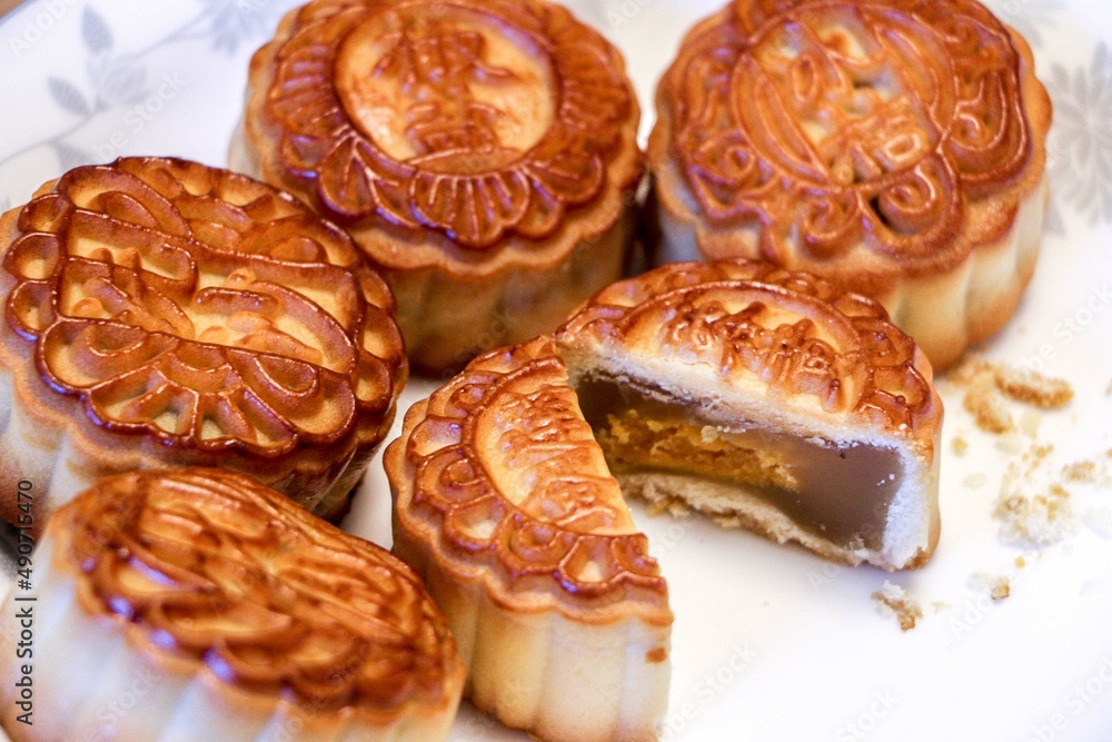 Whole mooncakes and one sliced mooncake showing delicious egg yolk and ...