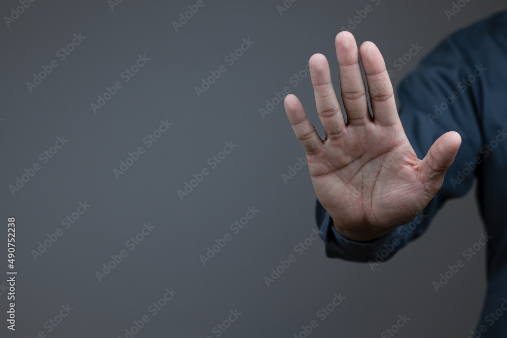man showing stop gesture reject on black background with empty space ...
