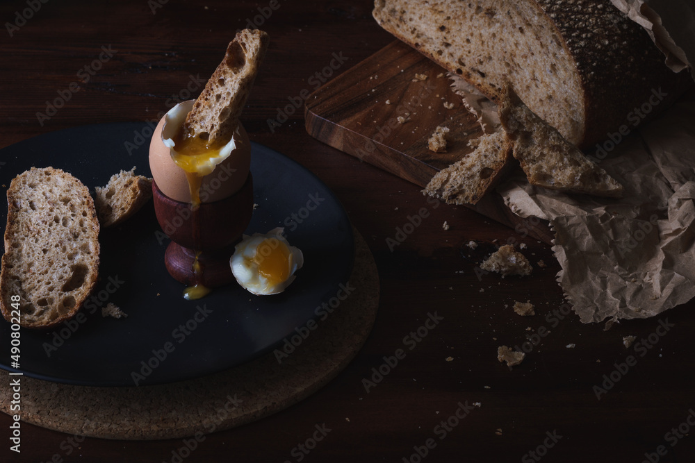 Breakfast table scene. Chiaroscuro style food photo. Cracked and open ...