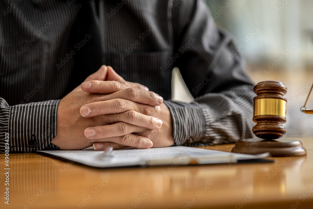 A lawyer sits in his office, on a table with a small hammer to beat the ...