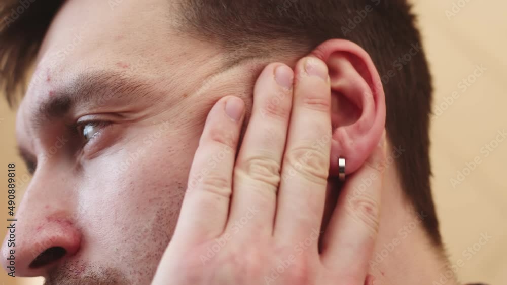 Vidéo Stock Man rubs his hand at temple because of ear pain, closeup ...