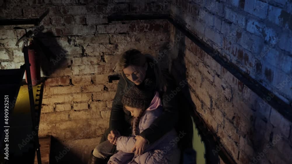 Ukrainian mother and child in the basement. With fear suffering and ...