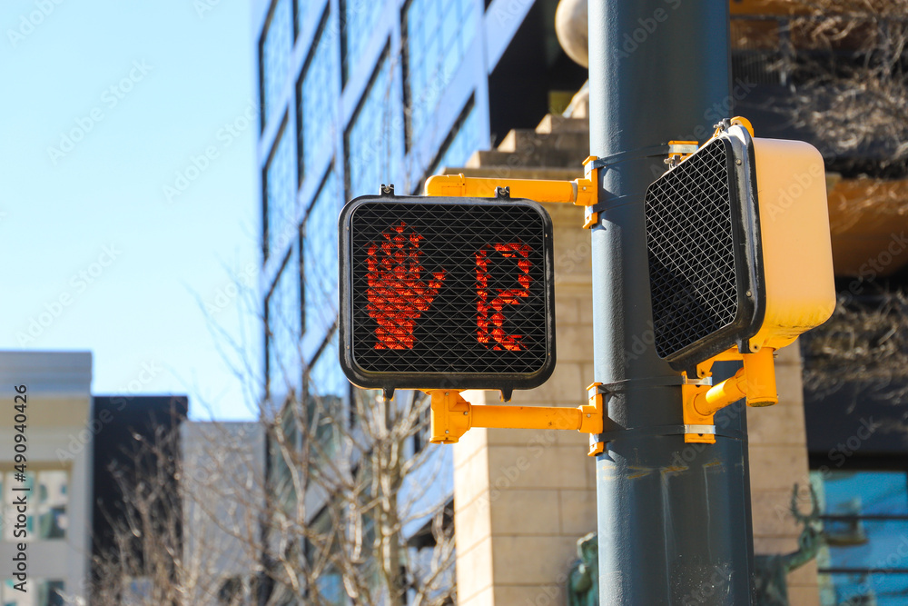 a yellow and black pedestrian traffic signal with a red number twelve ...