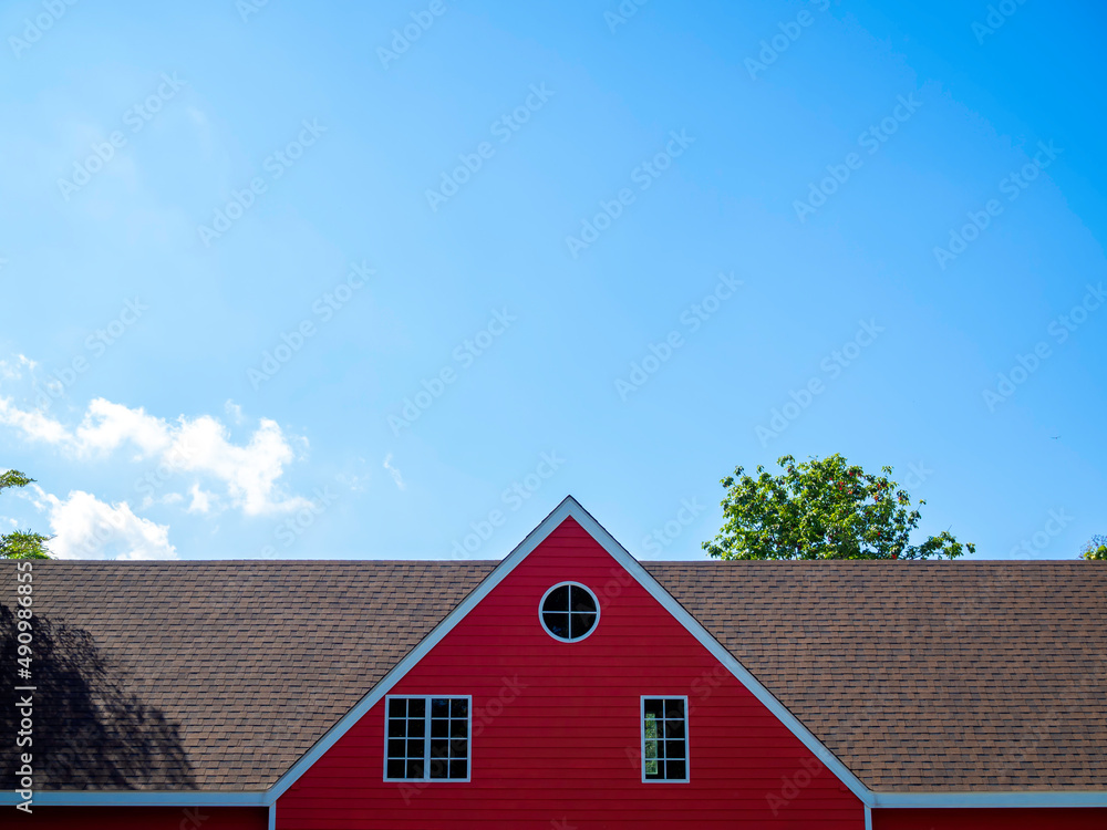 Red gable roof of big house covered with white wooden framed and ...
