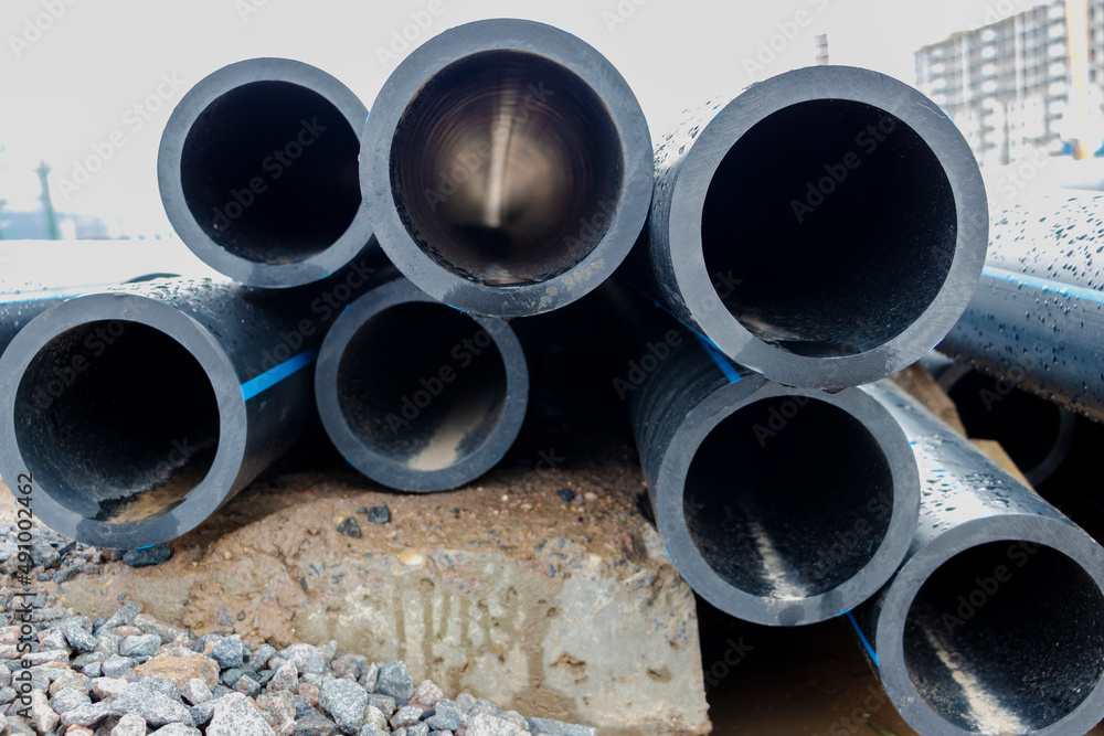 Water pipes for drinking water supply lie on the construction site ...