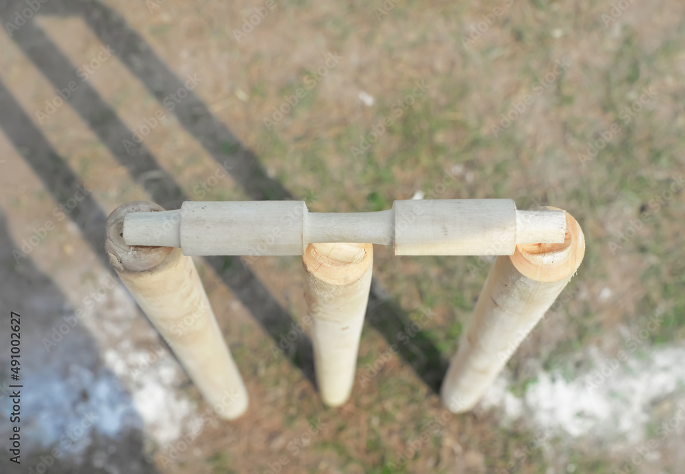 Old Grassy Cricket Pitch with selective focused Wooden Wickets in a ...