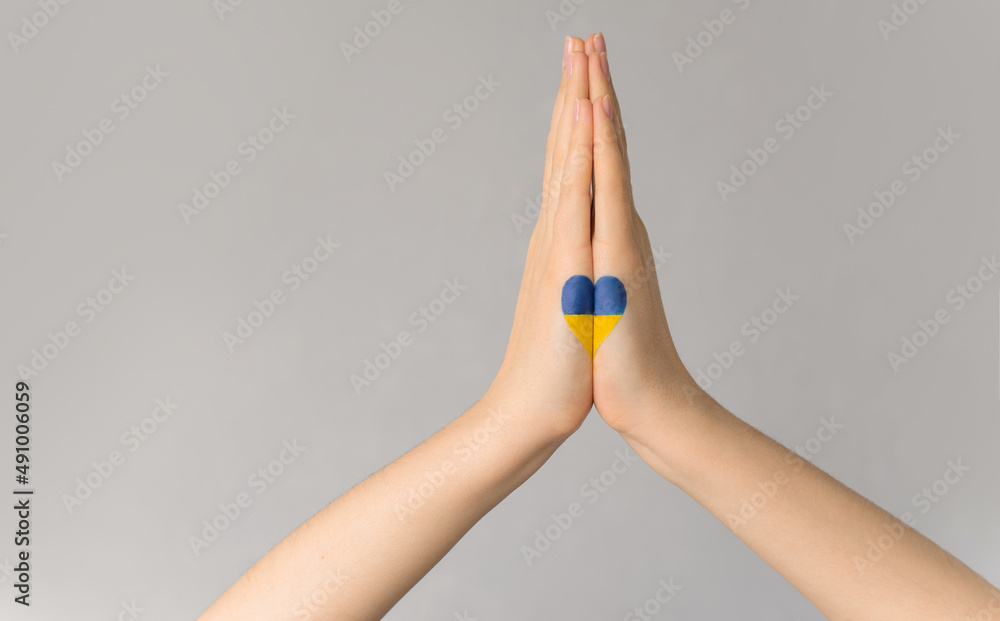 Pray for Ukraine: hands with a heart of the color of the Ukrainian flag ...