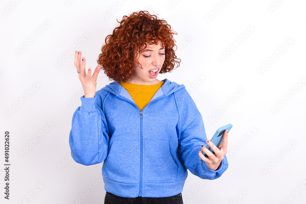 Photo of outraged annoyed young redhead girl wearing blue jacket over ...