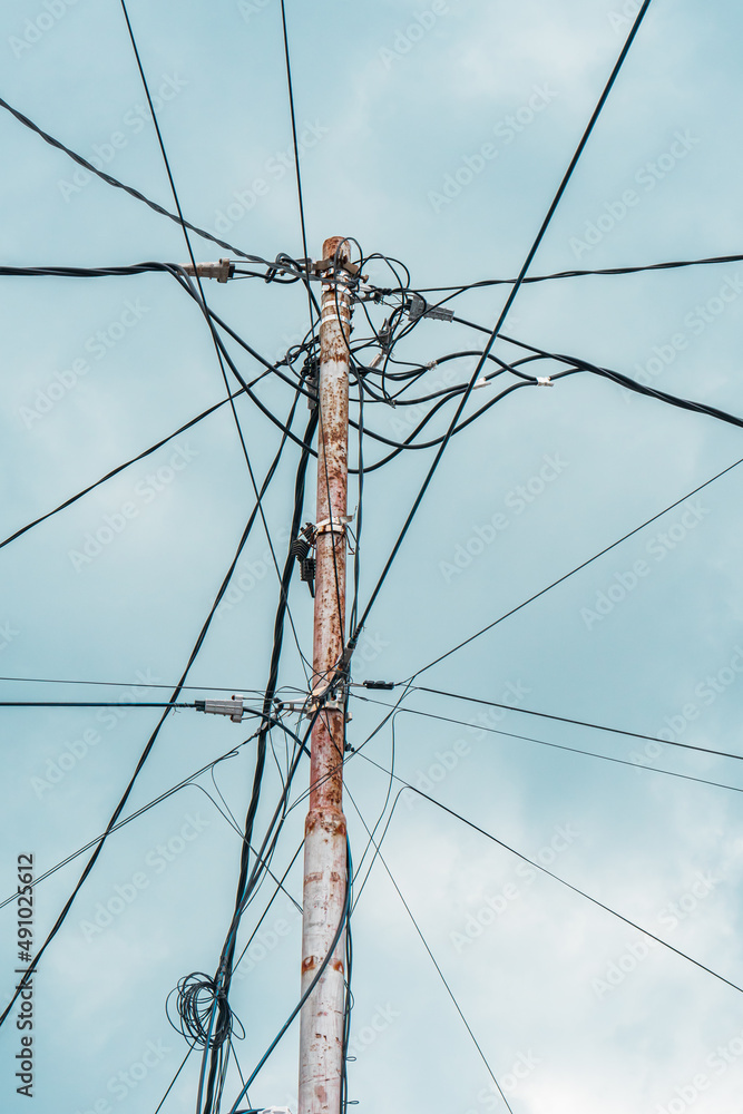 Street electric pole with many electrical wires and fiber optic cables ...