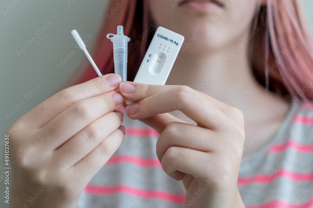 Teenage girl holding Covid-19 rapid antigen test cassette with negative ...