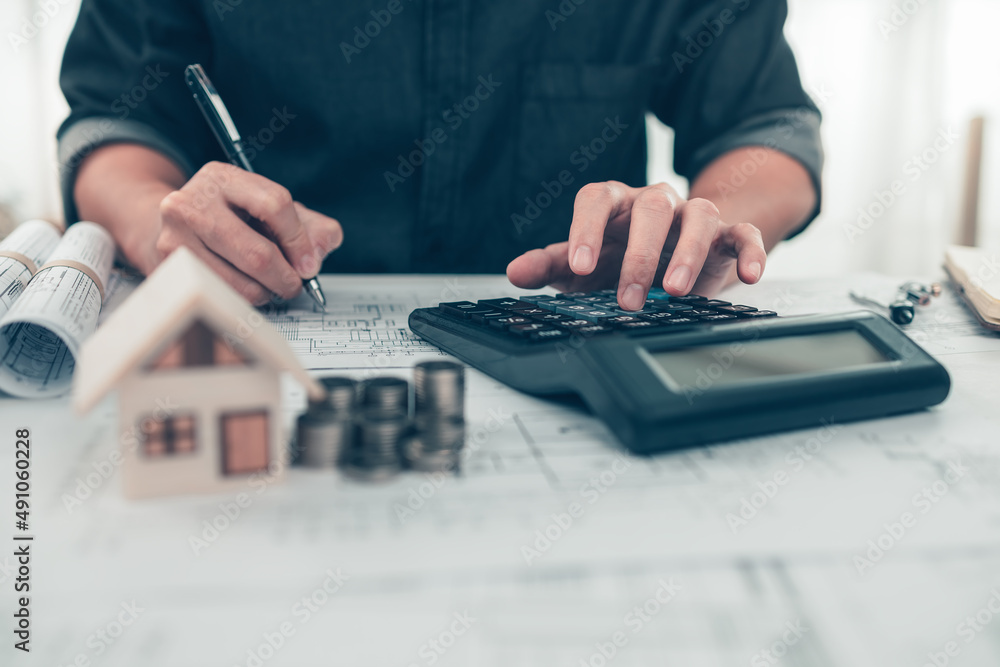Architect engineer use calculator check cost house design on blueprint ...