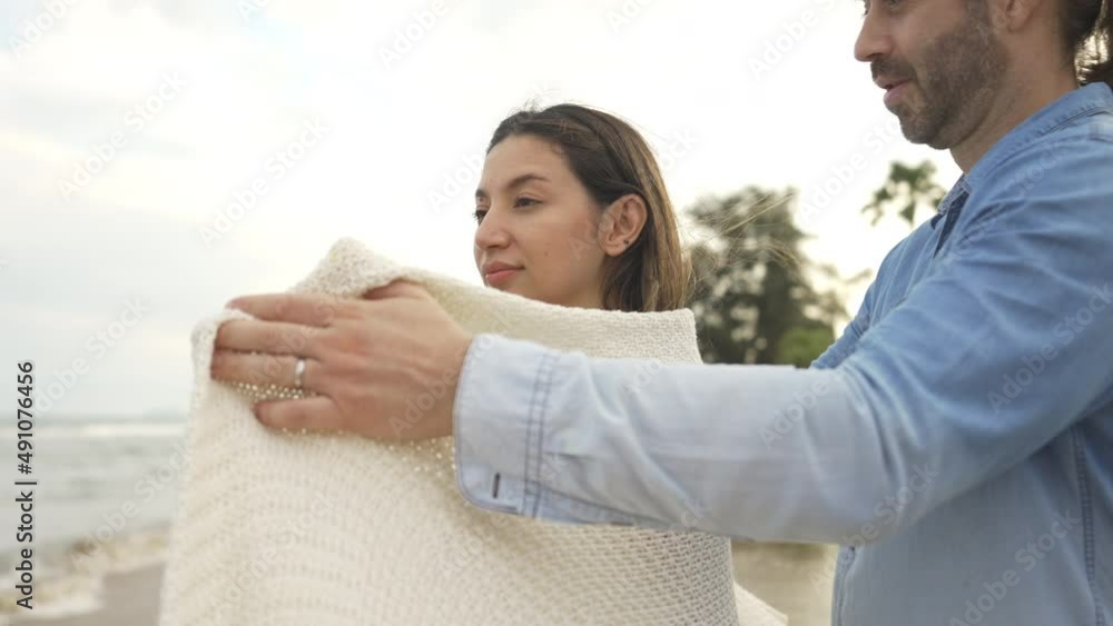 4K Caucasian couple husband cover his wife with a blanket and hugging ...