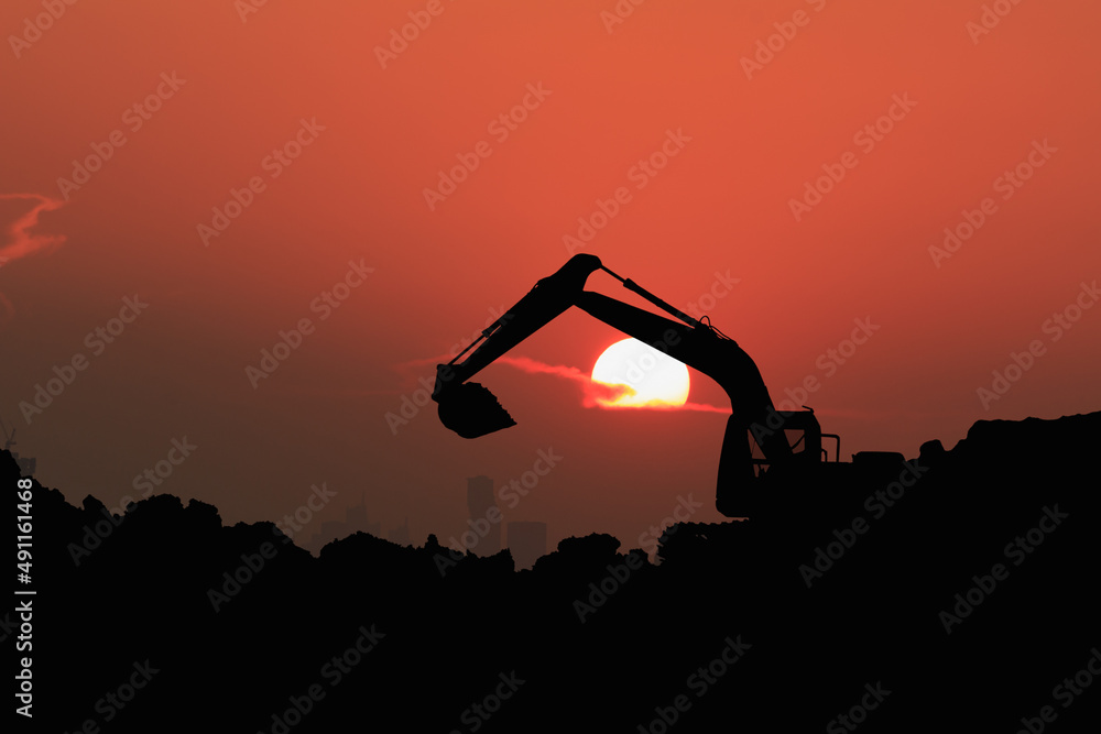 Excavators silhouette are digging soil with bucket lift up in the ...