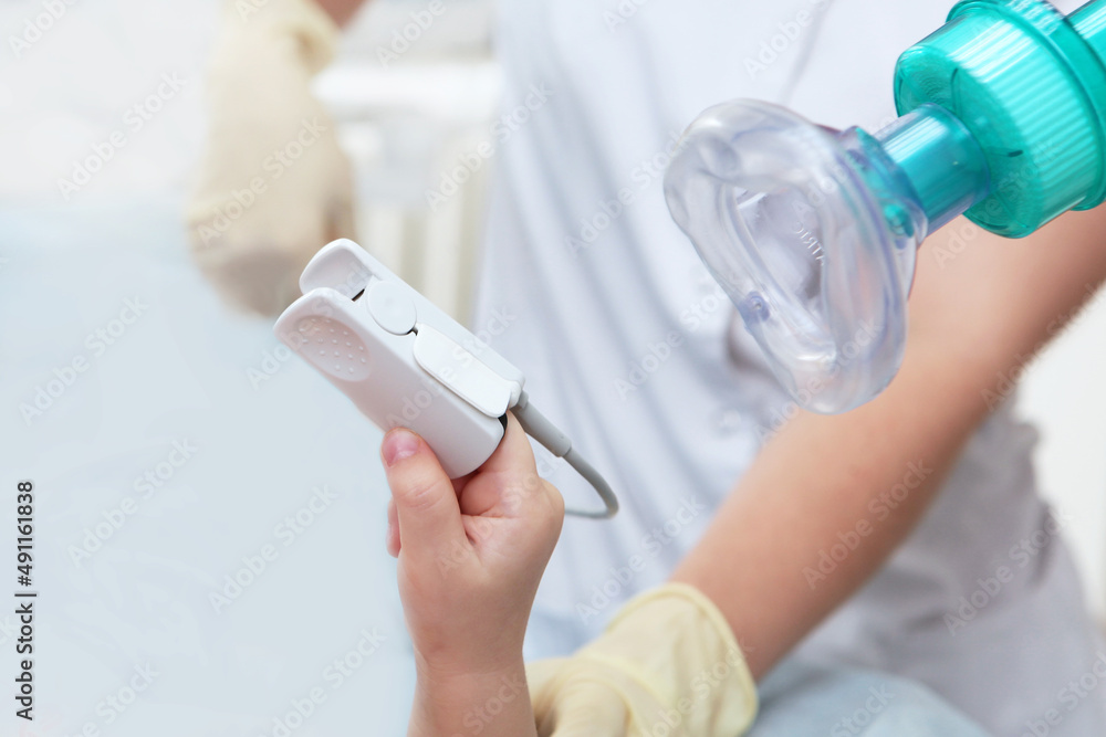 A child's hand with a device for measuring the level of oxygen in the ...