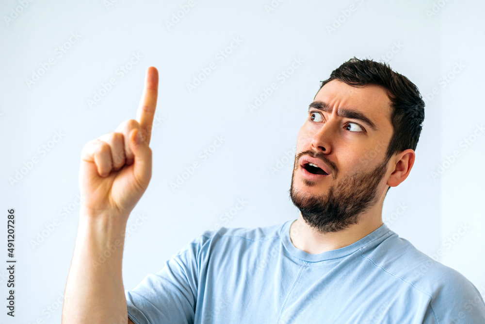 surprised young bearded handsome man wearing yellow hat cap standing ...