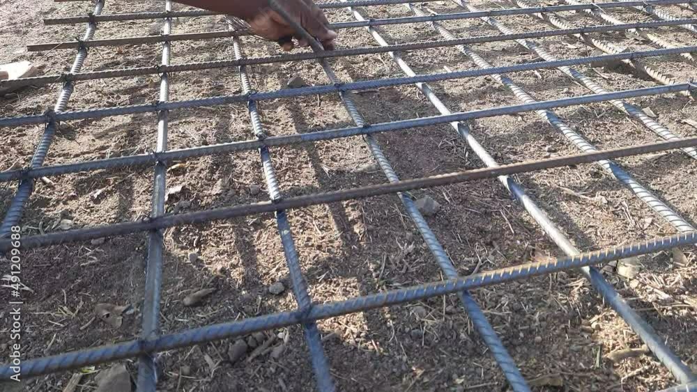 The worker`s hand tying reinforcing steel bars, tightening wire on ...