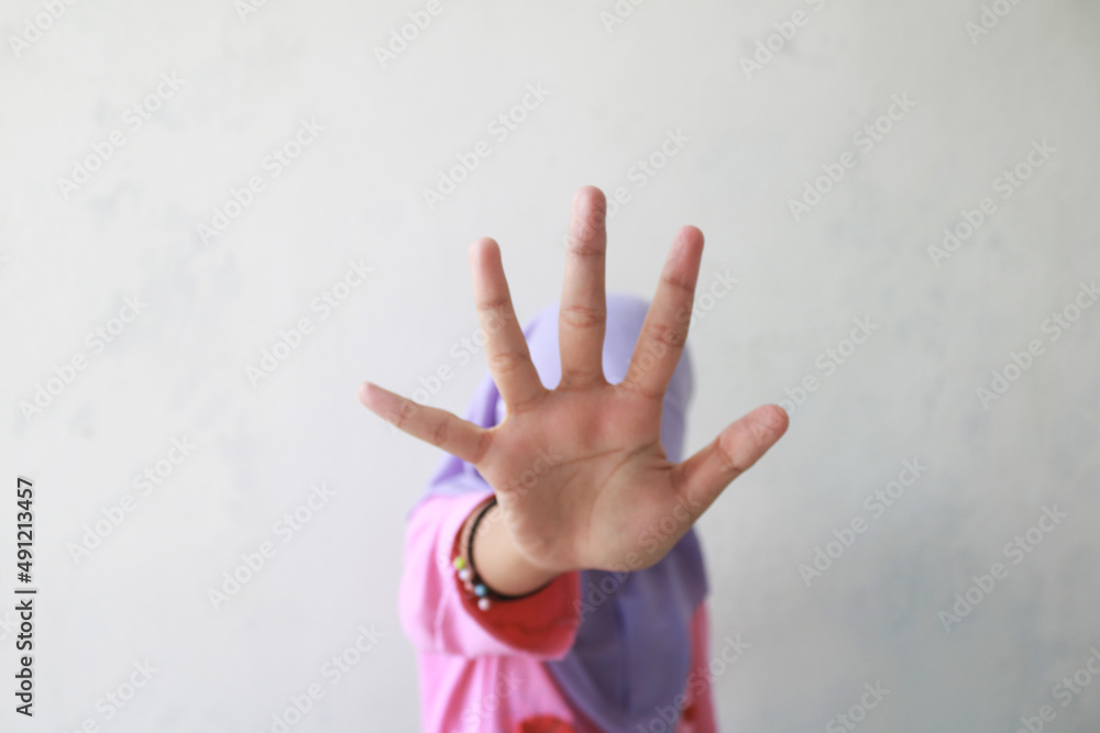 Close-up of little Asian girl stretching hands showing protest gesture ...