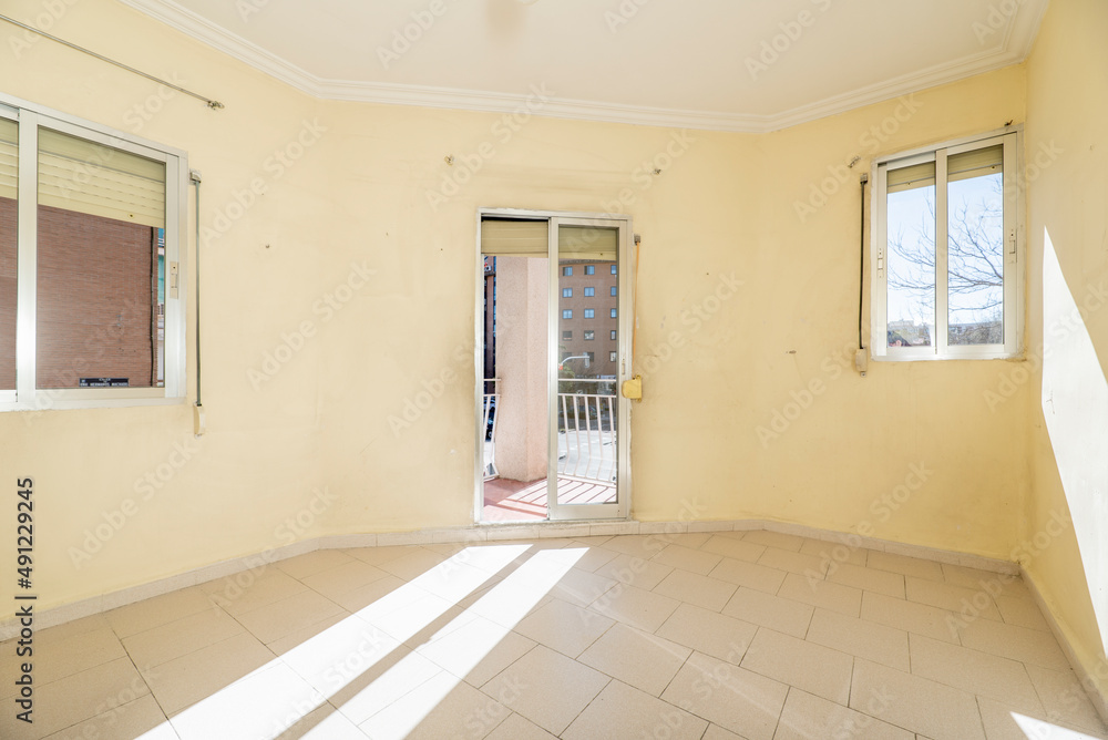 empty room with two windows and exit to a balcony in the center where a ...